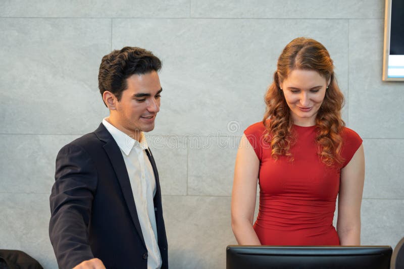Two Receptionists Standing and Working Behind the Reception Desk Stock ...