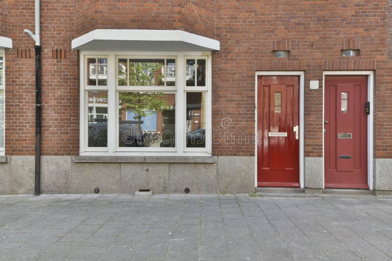 Two Red Doors on the Side of a Brick Building Stock Photo - Image of ...