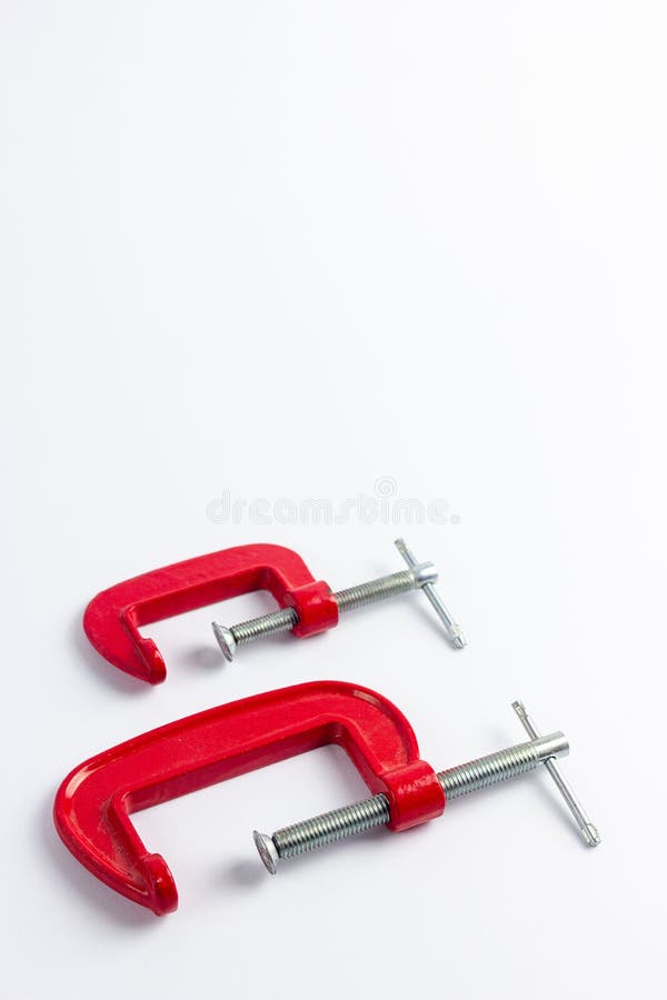 Two Red Metal Clamps of Different Sizes on a White Background Stock ...