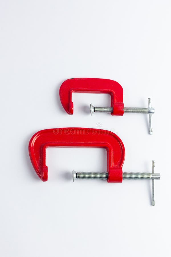 Two Red Metal Clamps of Different Sizes on a White Background Stock ...