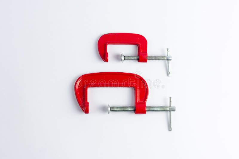 Two Red Metal Clamps of Different Sizes on a White Background. Tools ...