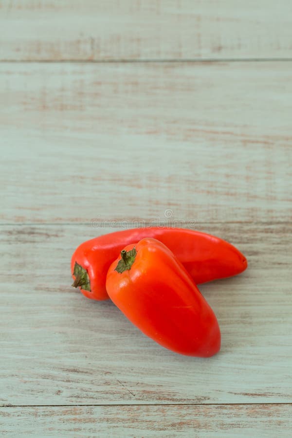 Two Red Mini Sweet Bell Peppers on Blue Wood Floor Stock Photo - Image ...