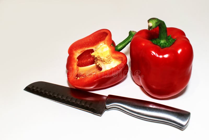 Two Red Peppers, One Cut Open and a Knife in Front Stock Photo - Image ...