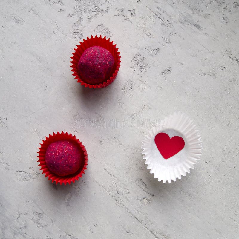 Two Red Truffles with Raspberry Filling in Red Heart on a Light Grey ...