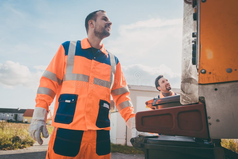 Two Refuse Collection Workers Loading Garbage into Waste Truck Stock ...