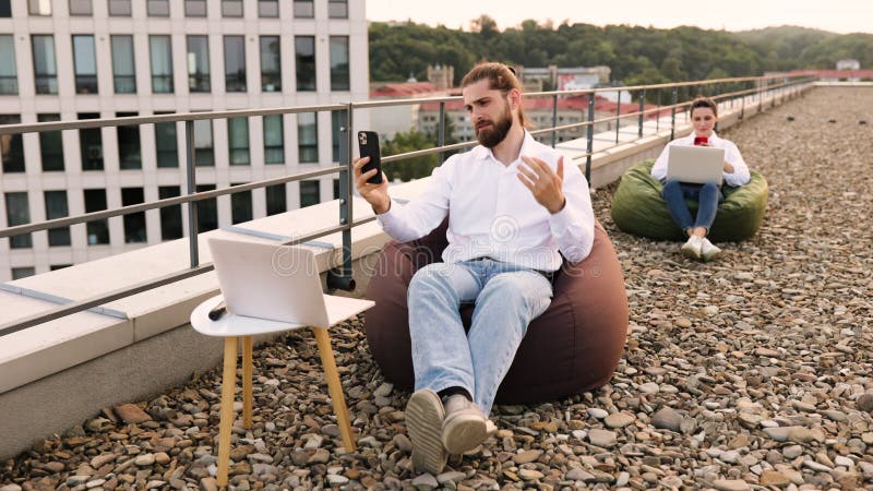 Remote Workers on Rooftop Working with Laptops and Smartphones Stock ...