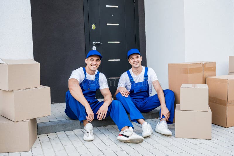 Two Removal Company Workers Have a Break while Sitting on the Step ...