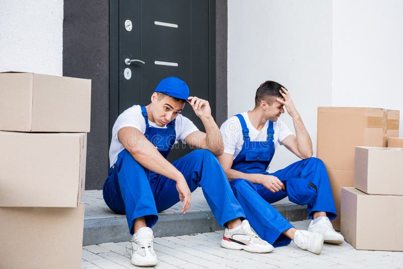 Two Removal Company Workers Have a Break while Sitting on the Step ...