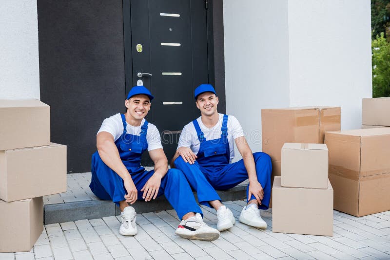 Two Removal Company Workers Have a Break while Sitting on the Step ...