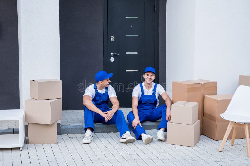 Two Removal Company Workers Have a Break while Sitting on the Step ...