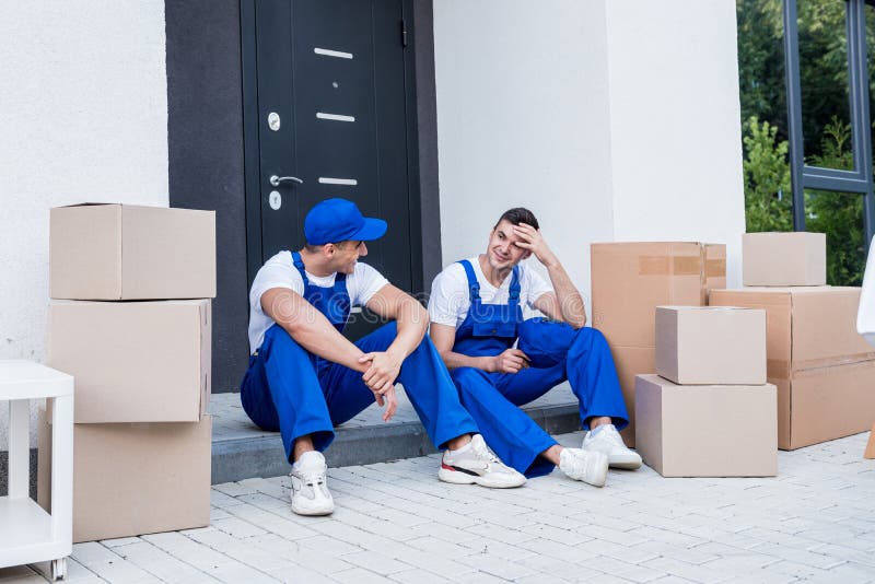 Two Removal Company Workers Have a Break while Sitting on the Step ...