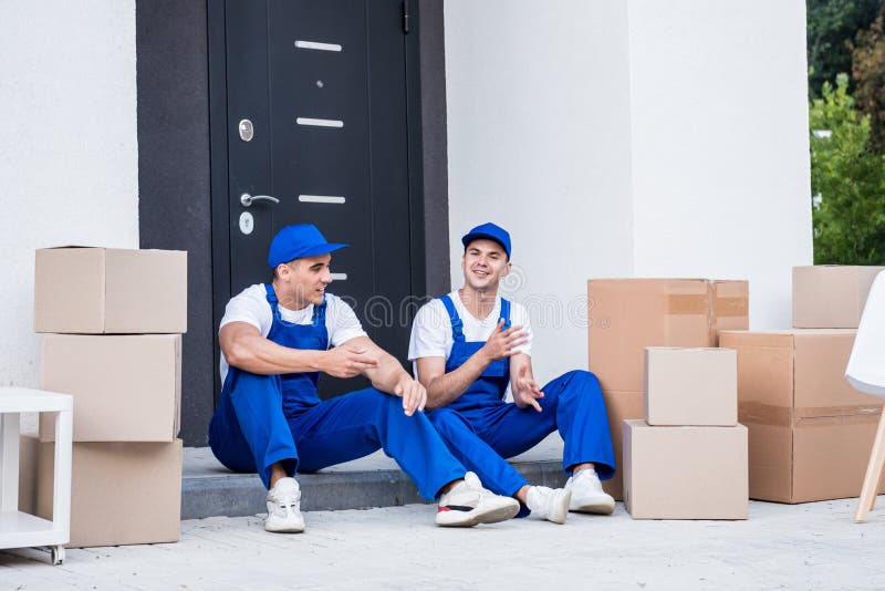 Two Removal Company Workers Have a Break while Sitting on the Step ...