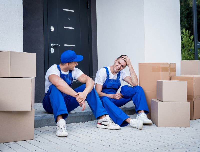 Two Removal Company Workers Have a Break while Sitting on the Step ...