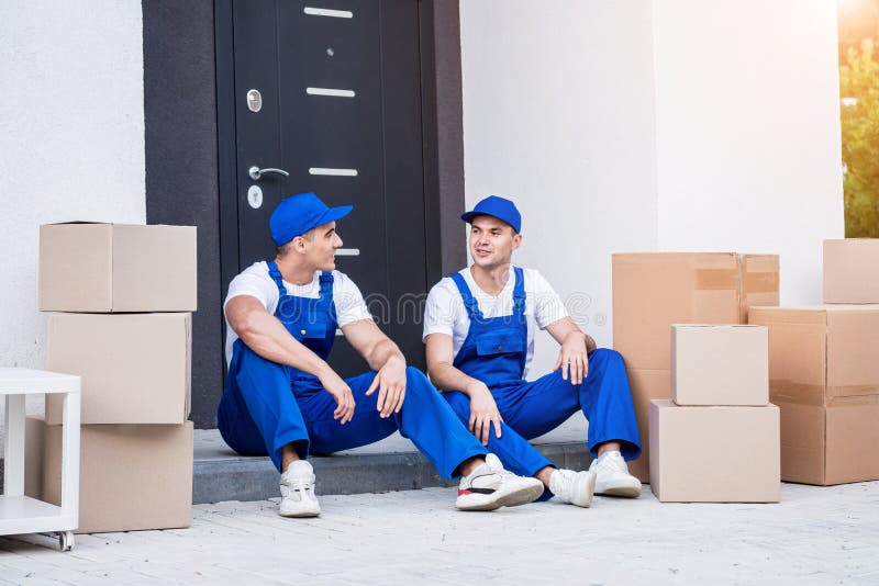Two Removal Company Workers Have a Break while Sitting on the Step ...