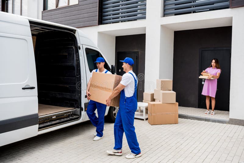 Two Removal Company Workers are Loading Boxes into a Minibus. Stock ...