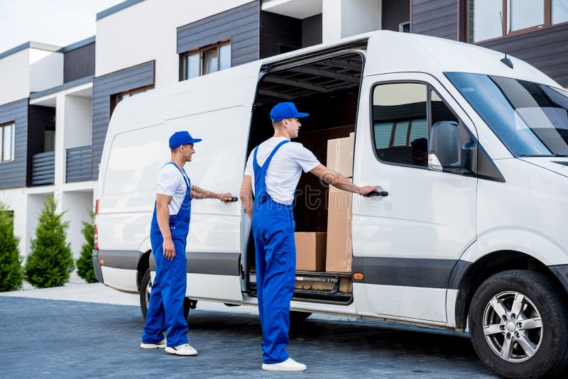 Two Removal Company Workers are Loading Boxes into a Minibus. Stock ...
