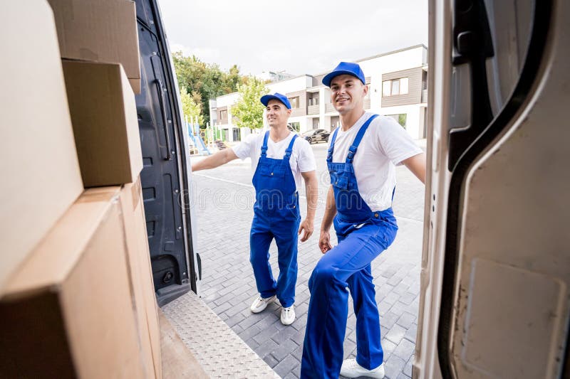 Two Removal Company Workers Unloading Boxes from Minibus Stock Photo ...