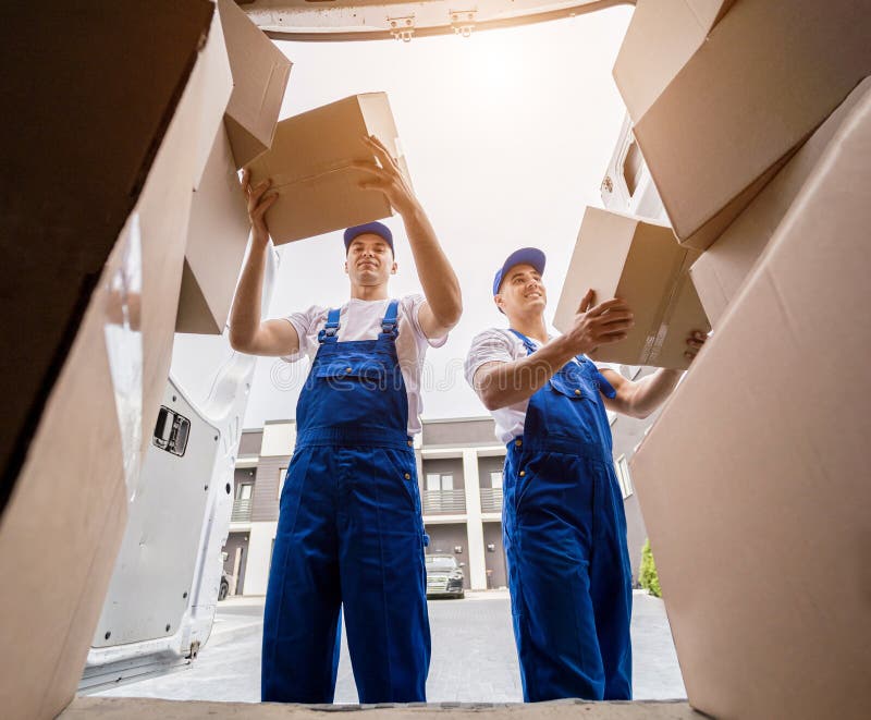 Two Removal Company Workers Unloading Boxes from Minibus Stock Photo ...