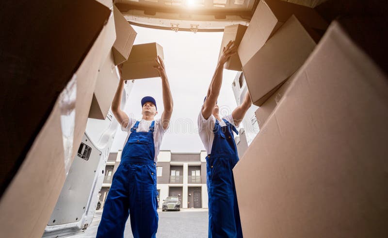 Two Removal Company Workers Unloading Boxes from Minibus Stock Photo ...