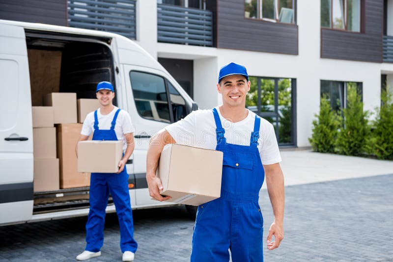 Two Removal Company Workers Unloading Boxes from Minibus into New Home ...