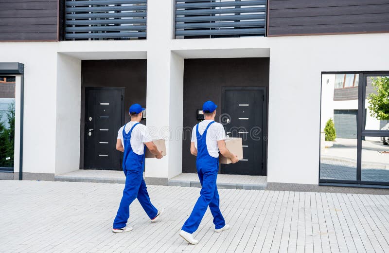 Two Removal Company Workers Unloading Boxes from Minibus into New Home ...