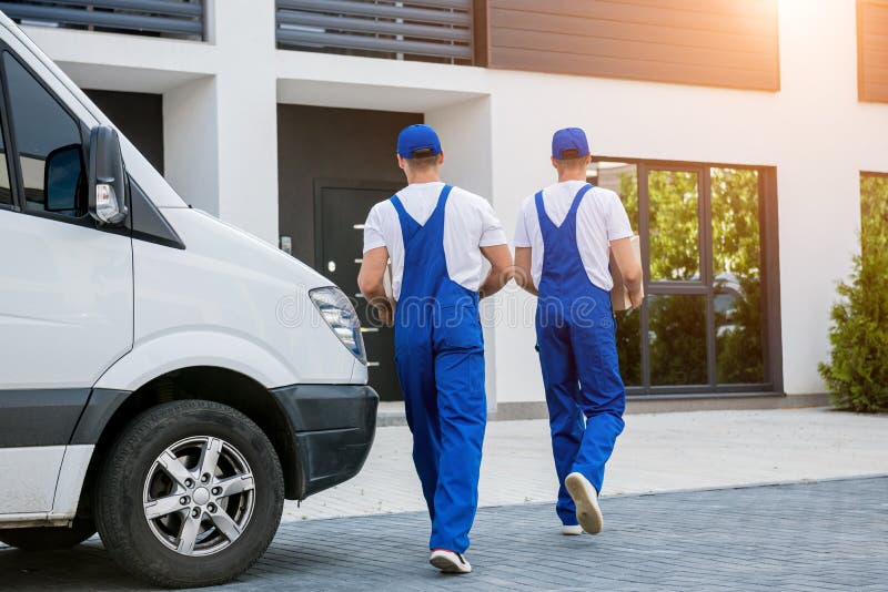 Two Removal Company Workers Unloading Boxes from Minibus into New Home ...