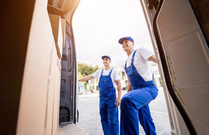 Two Removal Company Workers Unloading Boxes from Minibus Stock Image ...
