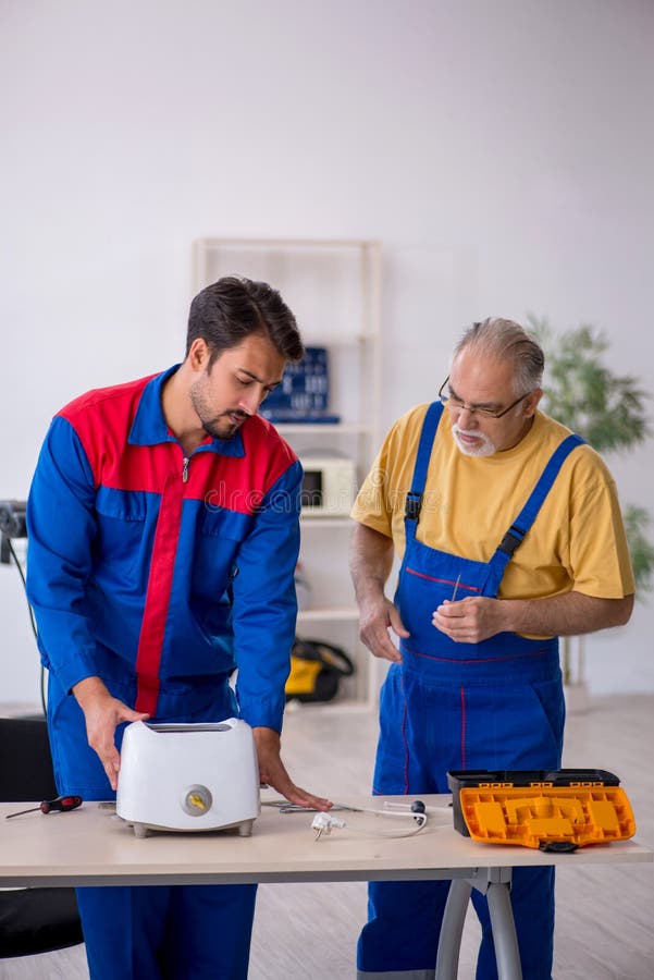 Two Male Repairmen Working at Workshop Stock Image - Image of ...
