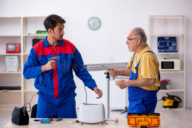 Two Male Repairmen Working at Workshop Stock Image - Image of electric ...