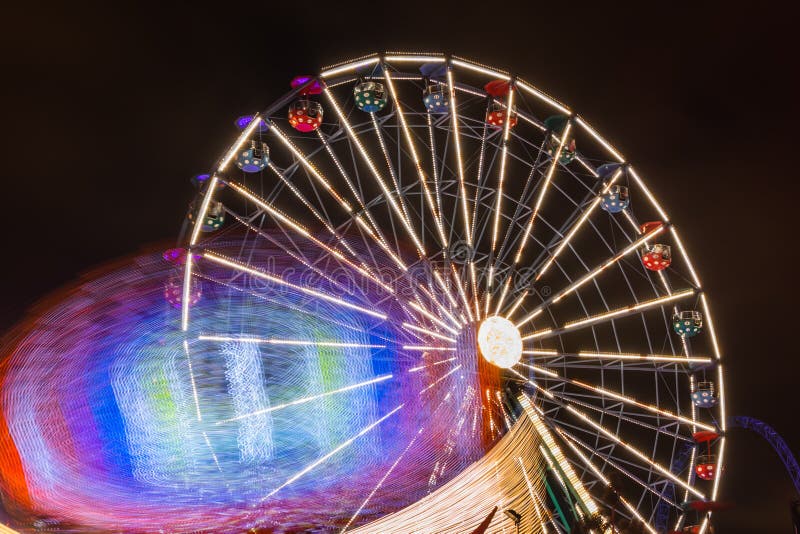 Two Rides in Motion in Amusement Park, Night Illumination. Long ...