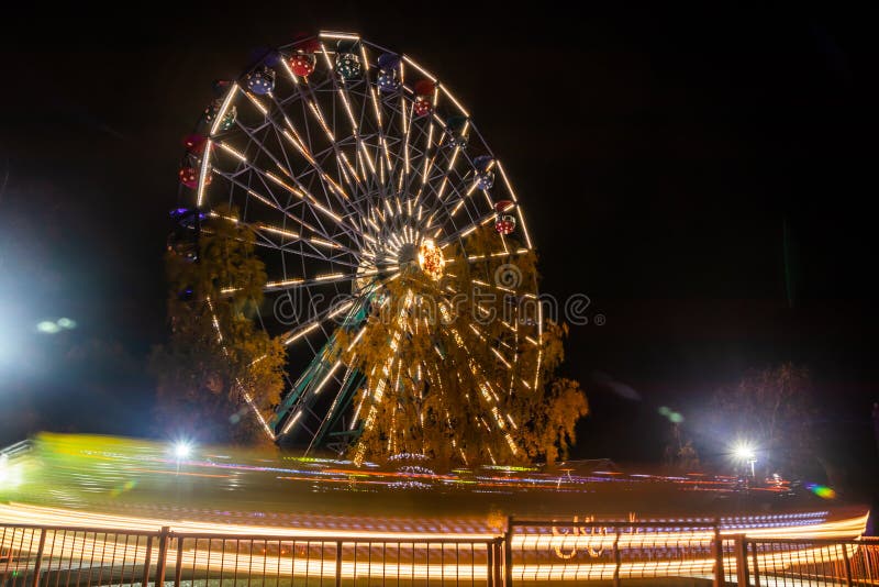 Two Rides in Motion in Amusement Park, Night Illumination. Long ...