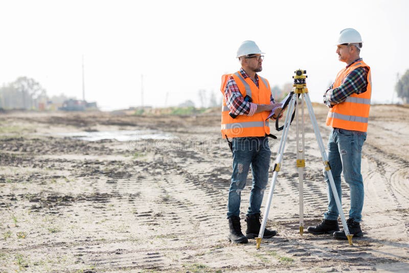 Road Construction Workers Using Measuring Device on the Field Stock ...