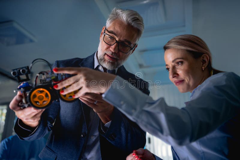 Two Robotics Engineers Assembling Robotic Car. Concept of Modern ...