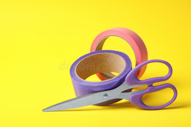 Two Rolls of Adhesive Tape and Scissors on Yellow Background. Space for ...