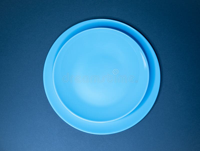 Two Round Ceramic Blue Plates on a Blue Background Stock Photo - Image ...