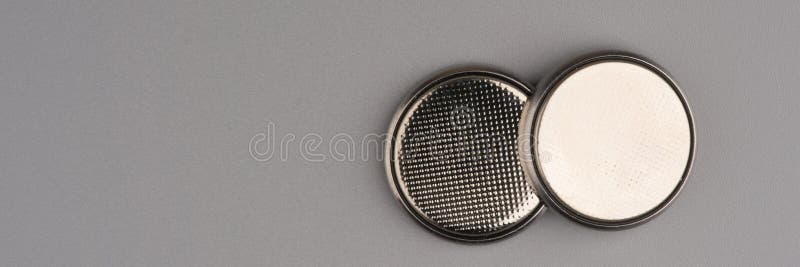 Two Round Flat Batteries on a Gray Background. Lots of Space for Text ...