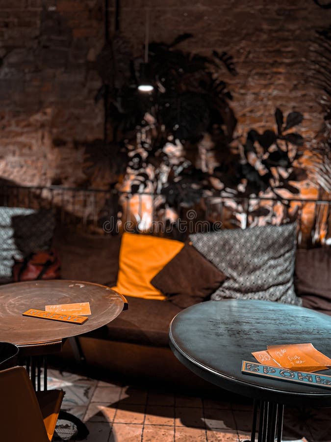 Two Round Tables in a Restaurant in Front of a Sofa with Pillows Stock ...