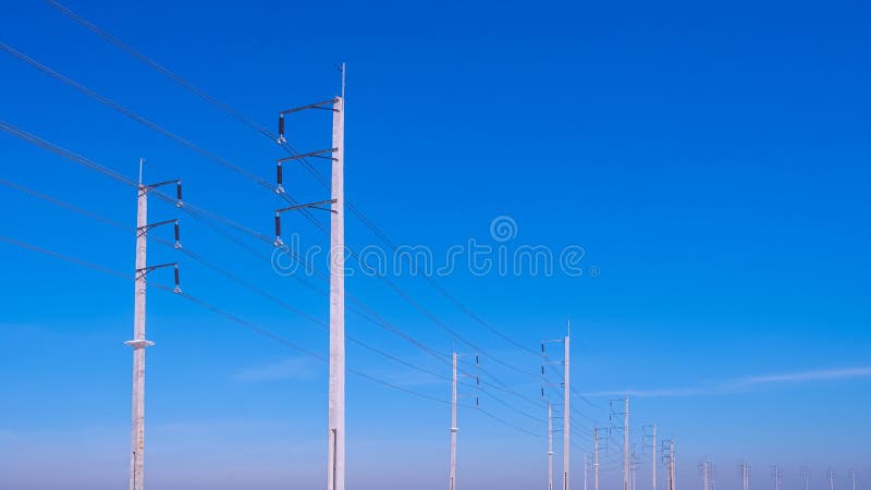 Two Rows of Electric Poles with Cable Lines Against Blue Sky Background ...