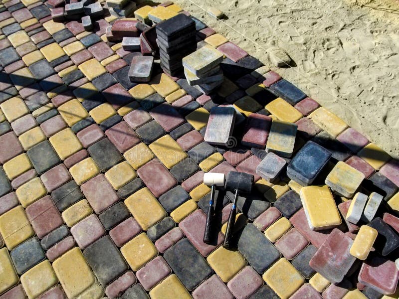 Two Rubber Mallets Lie on the Surface of a Multicolored Paving Slab ...