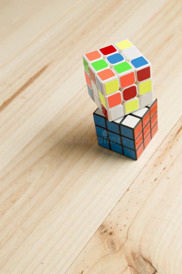 Two Rubik Cubes on a Background of Pine Wood. Editorial Photography ...