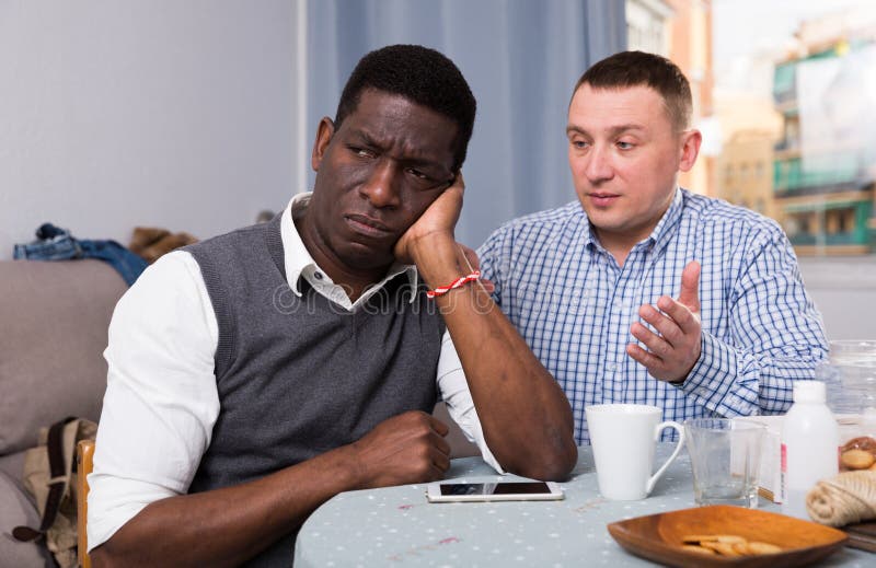 Two Sad Interracial Men Sitting at Table after Conflict Stock Image ... Two Sad Interracial Men Sitting at Table after Conflict Stock Image ...