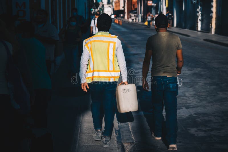 Two Sad Men Walking with Empty Can of Diesel Fuel in the Street ...
