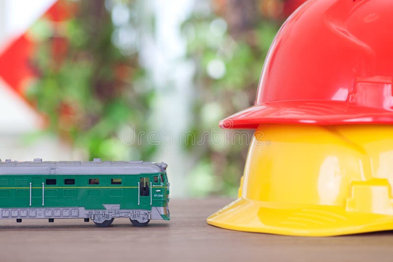 Two Safety Helmets and a Model Green Train on the Table Stock Image ...