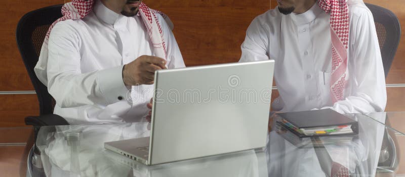 Two Saudi Businessmen Working on a Laptop Stock Photo - Image of arab ...