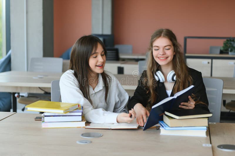 Two Schoolgirl Friends Study Together. they Sit at Their Desks and ...