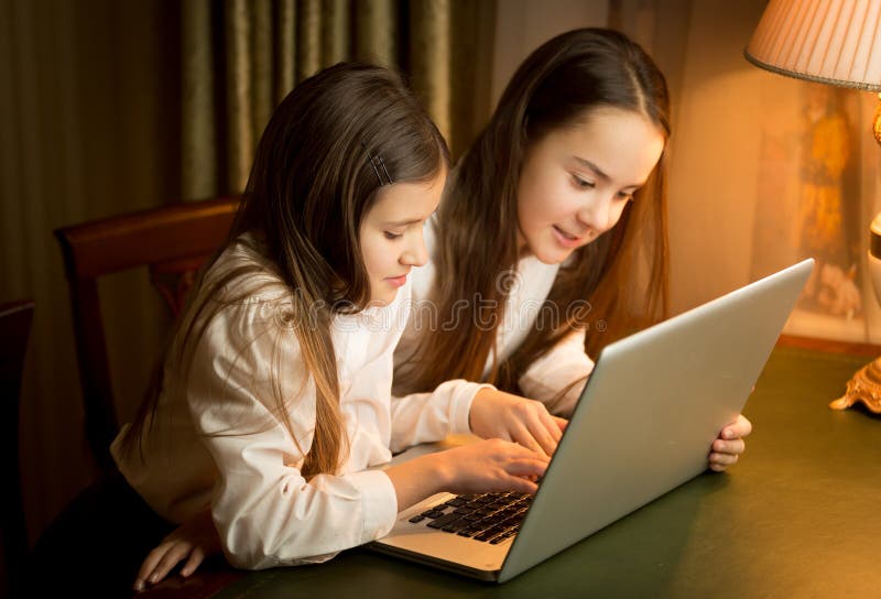 Two Schoolgirls Doing Homework at Laptop at Night Stock Photo - Image ...