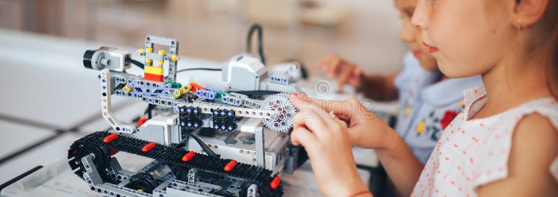 Two Schoolgirls Study in a Robotics Class, Assemble a Robot Constructor ...