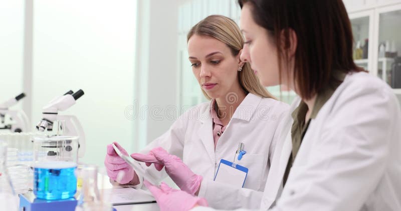 Two Scientists Collaborate in a Modern Laboratory during the Day and ...