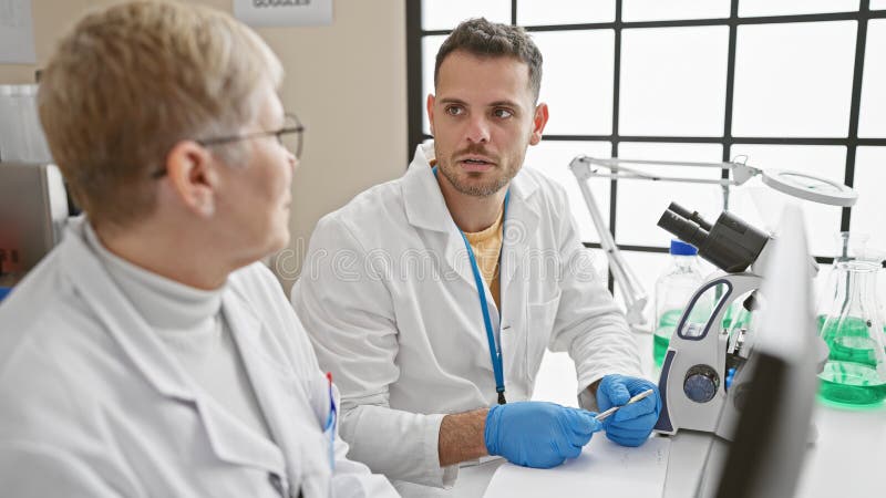 Two Scientists, a Man and a Woman, Collaborate in a Laboratory ...