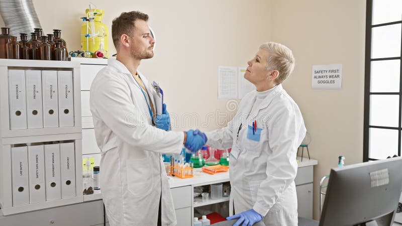 Two Scientists, a Man and a Woman, Handshake in a Well-equipped ...